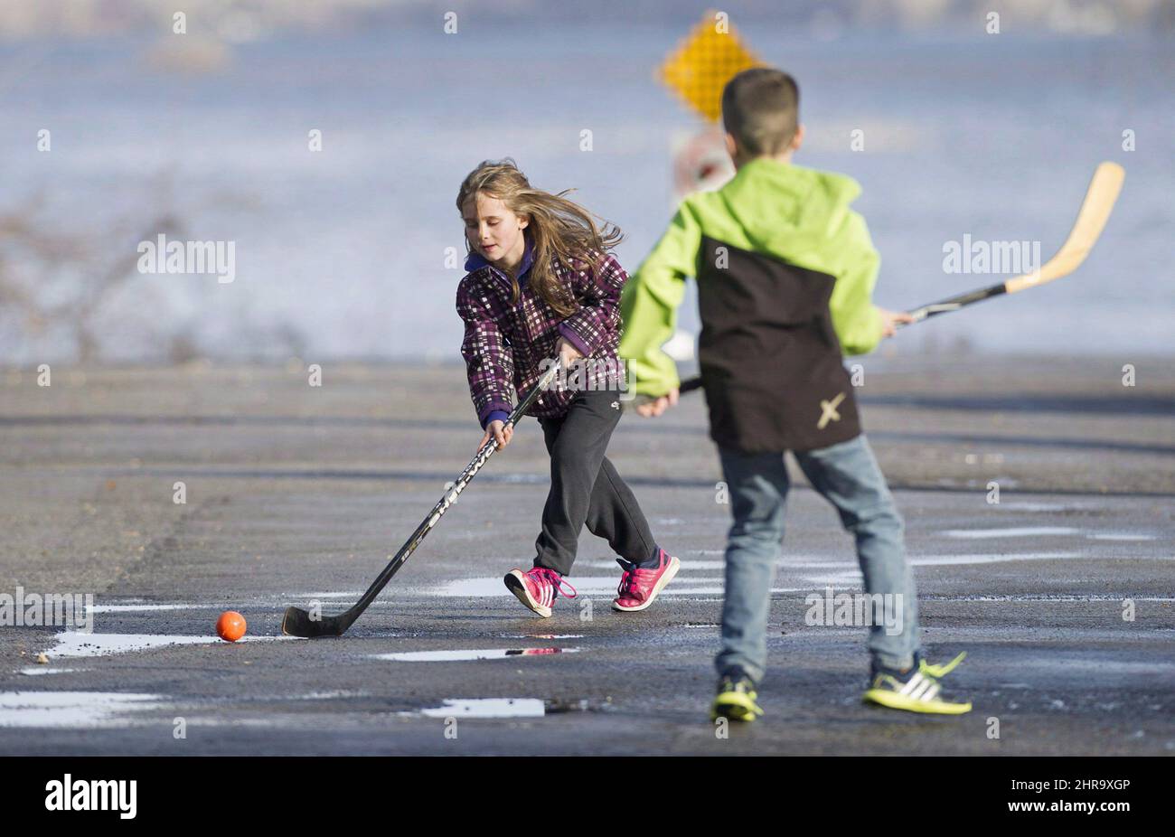 Emile Castonguay and his sister Adele, left, play a game of ball hockey ...