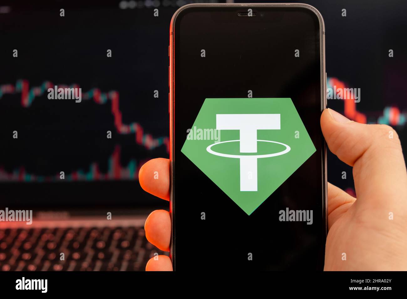 Tether USDT cryptocurrency logo on the screen of smartphone in mans ...