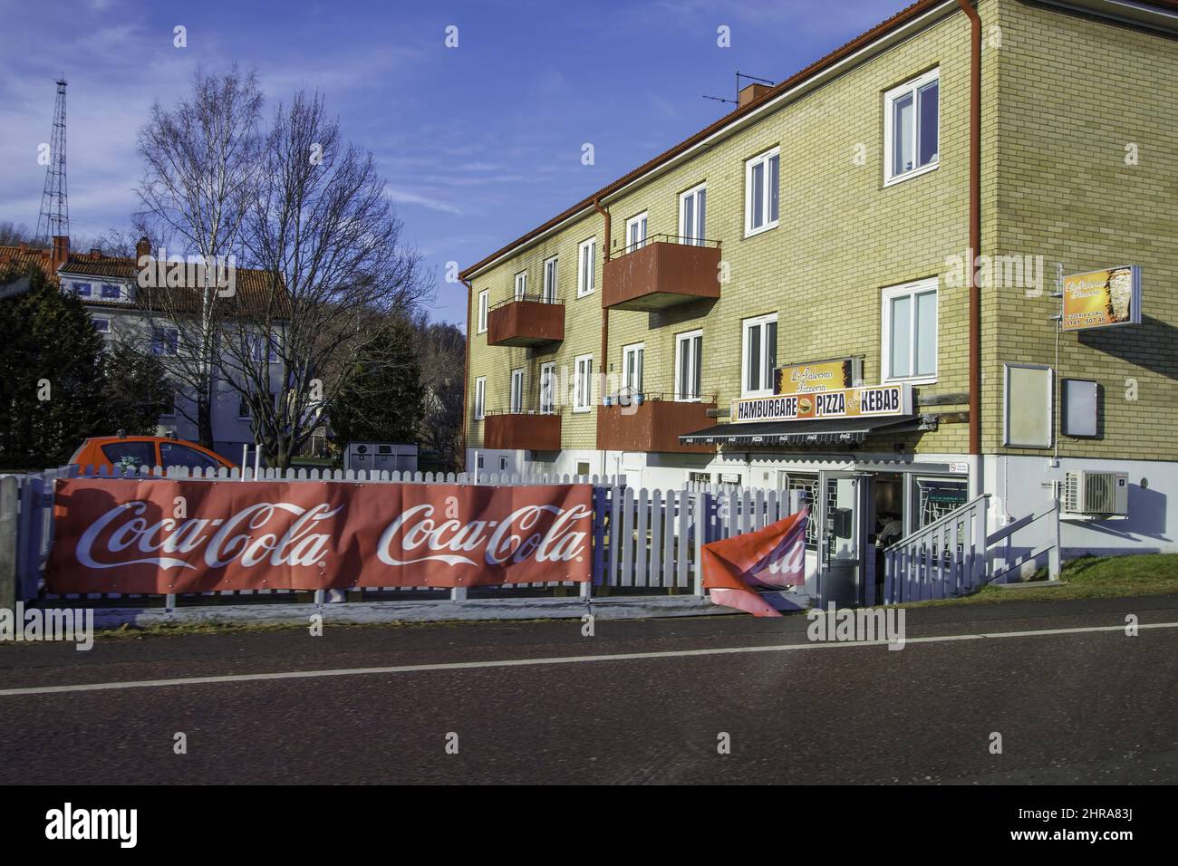 Coca-Cola signboard on a barrier next to a building in Motala, Sweden ...