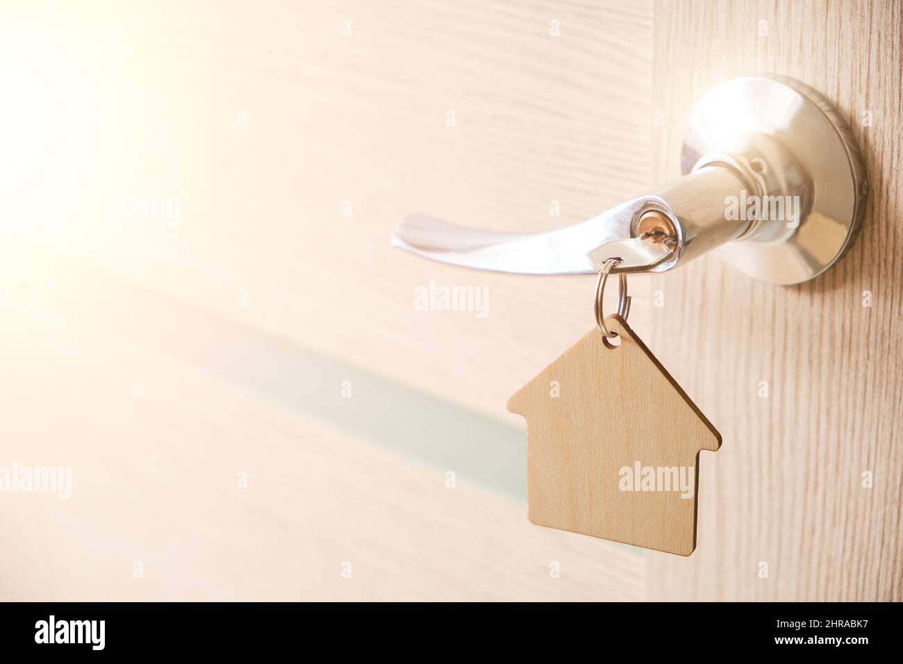 Key with keychain in form house in door lock.With bright sunlight Stock ...