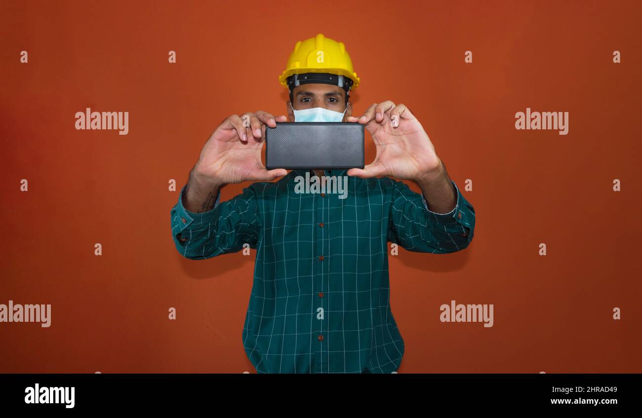 Engineer, architect or worker with yellow helmet and pandemic mask ...