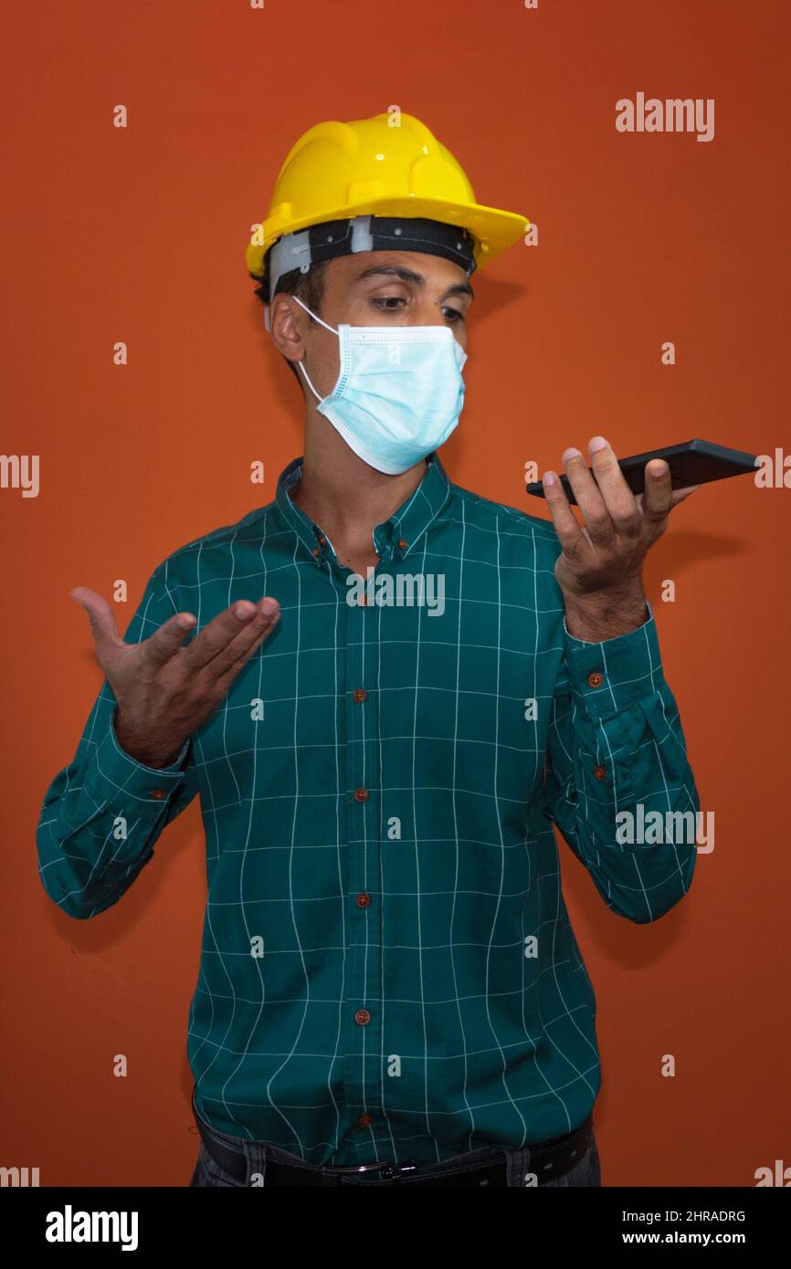 Engineer, architect or worker with yellow helmet and pandemic mask ...