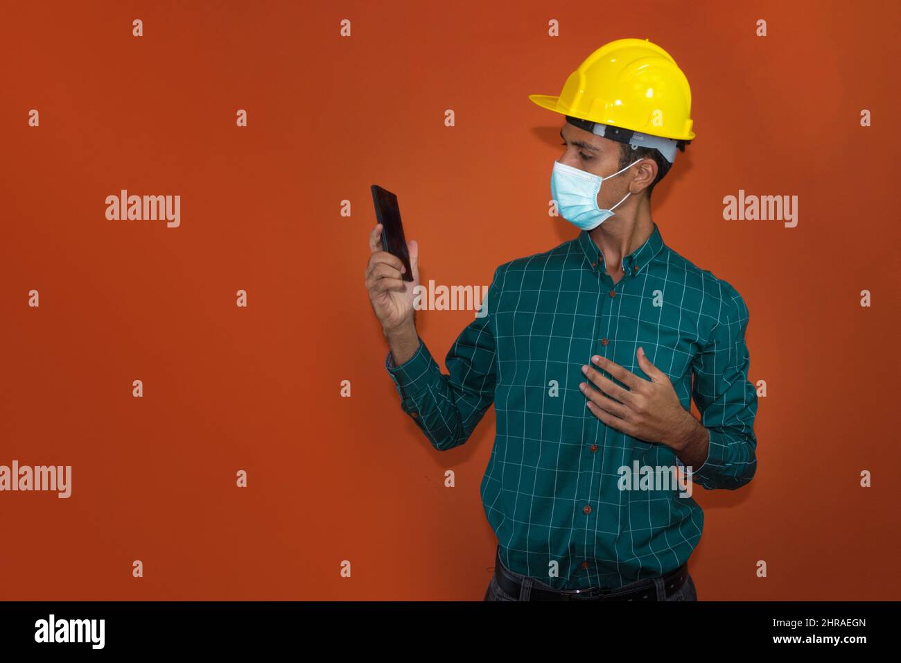 Engineer, architect or worker with yellow helmet and pandemic mask ...