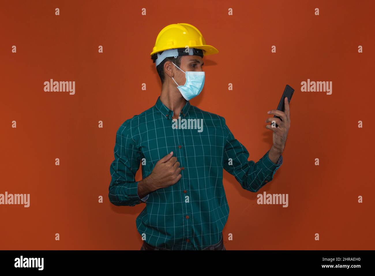 Engineer, architect or worker with yellow helmet and pandemic mask ...