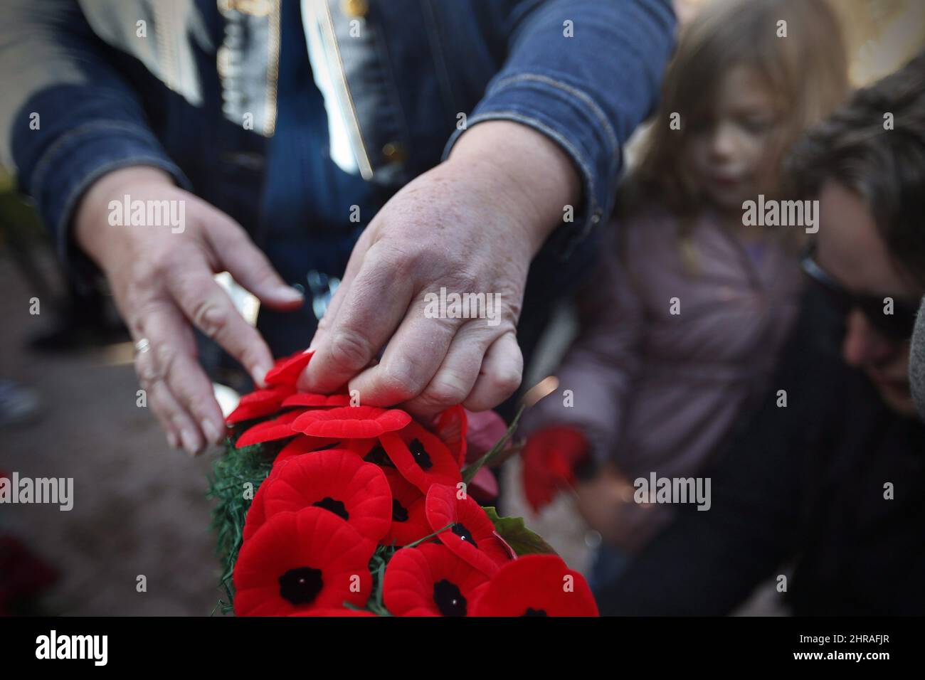 People place their poppies during a Remembrance Day ceremony at Vimy ...