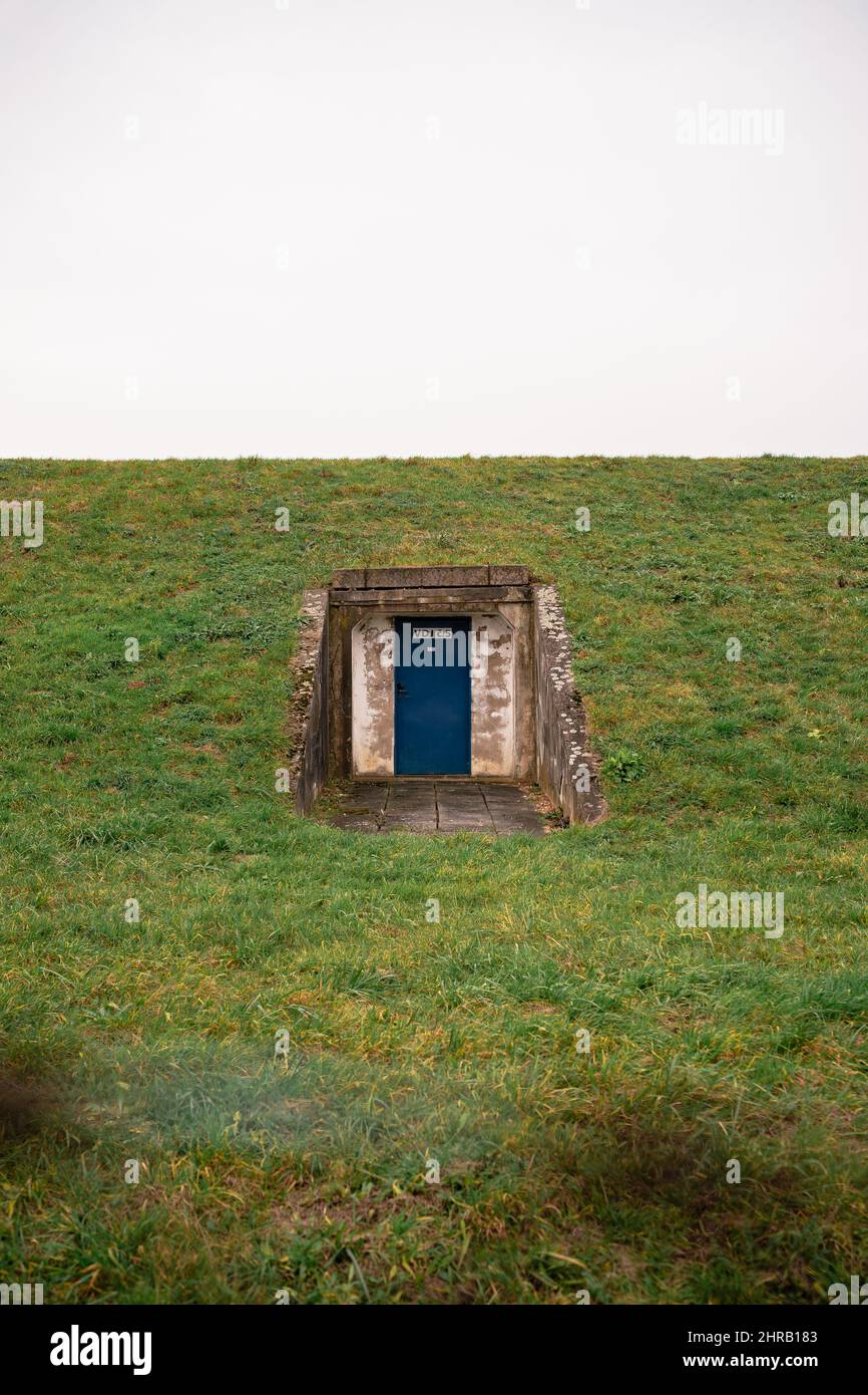 Vertical shot of a bunker in a field with cloudless sky background ...