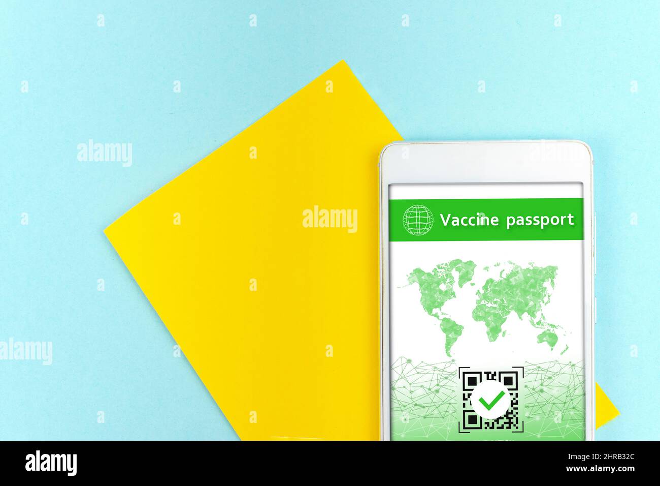 Yellow a piece of paper and smartphone with a valid QR code on blue ...