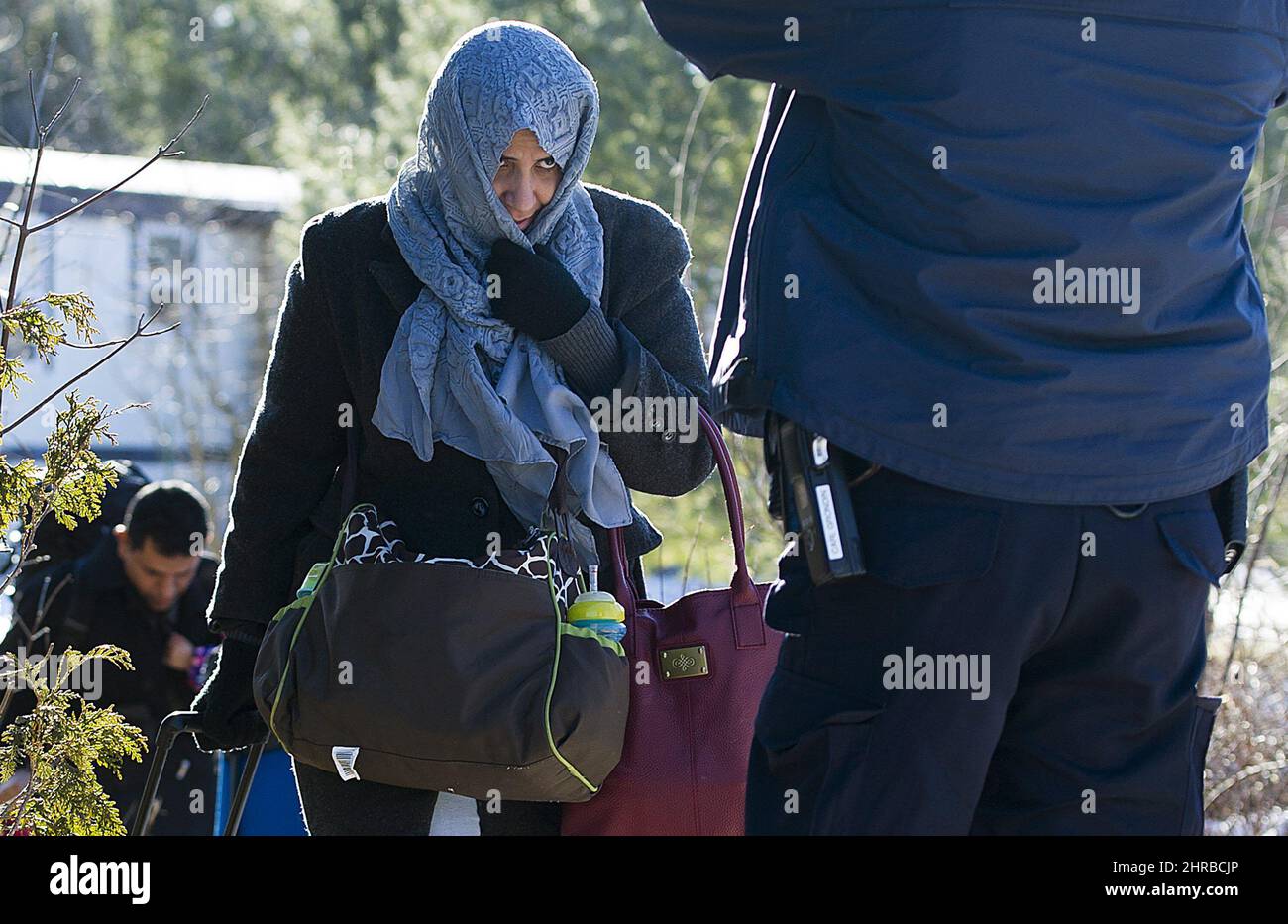 A woman and her family claiming to be from Yemen looks up as an RCMP ...