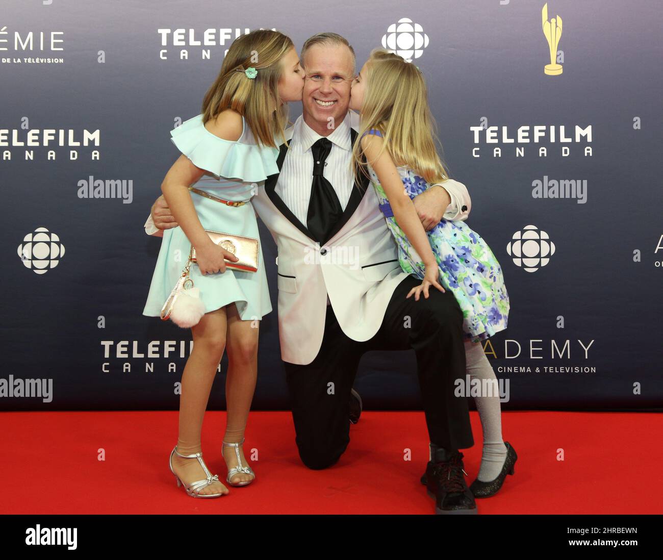 Gerry Dee gets a kiss on the red carpet from his daughters Aly, left ...