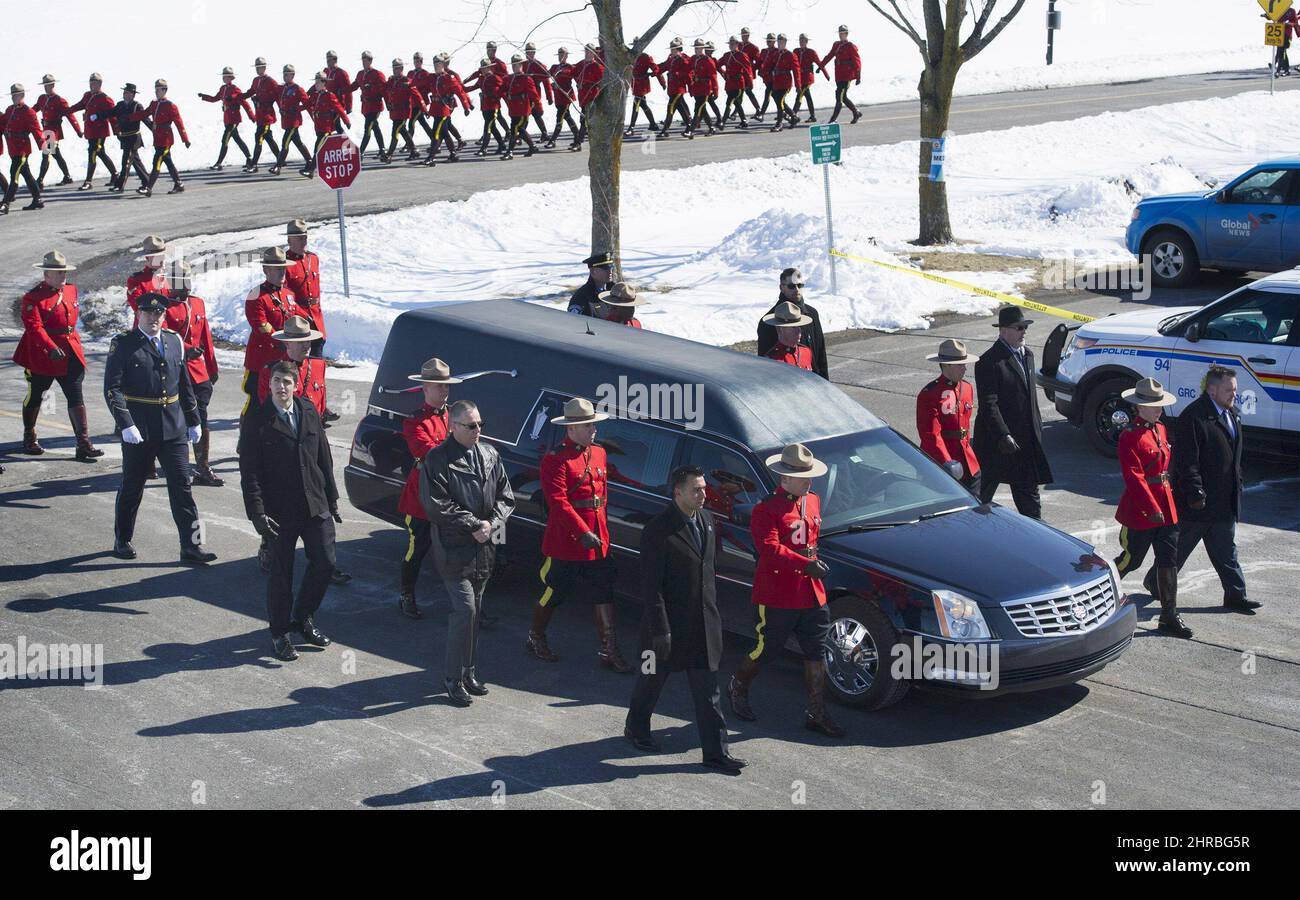 RCMP officers lead the procession next to the hearse containing the ...