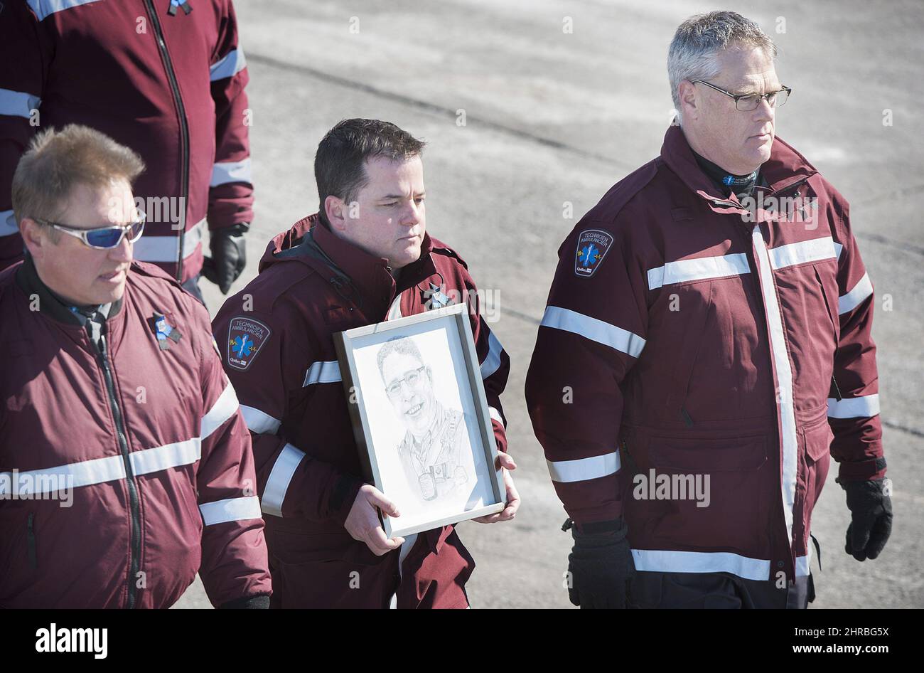 Emergency first responders carry a portrait of RCMP Constable Richer ...