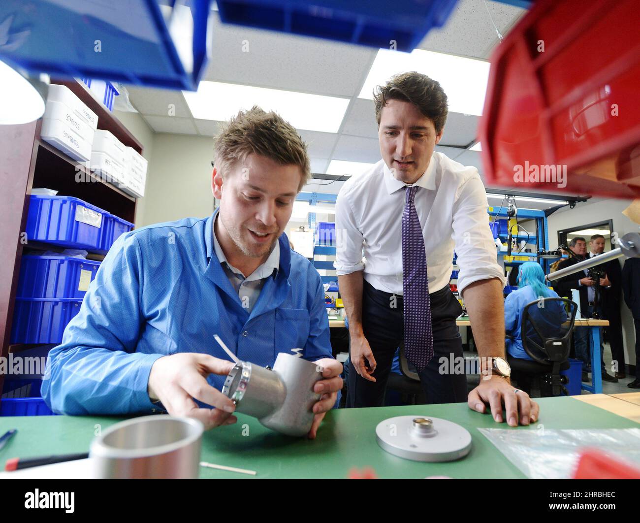 Prime Minister Justin Trudeau looks on as a Kinova Robotics employee ...