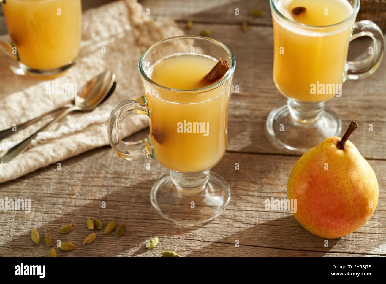 Homemade hot pear drink with cinnamon in glass cups with fresh fruit ...