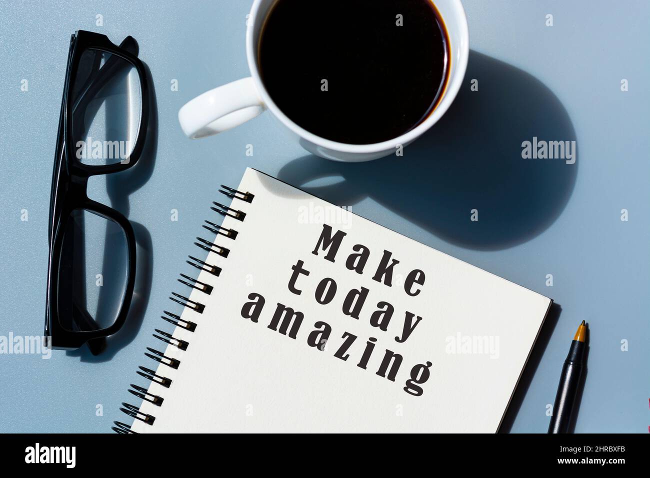 Motivational quote on notepad with potted plant, glasses and a pen ...