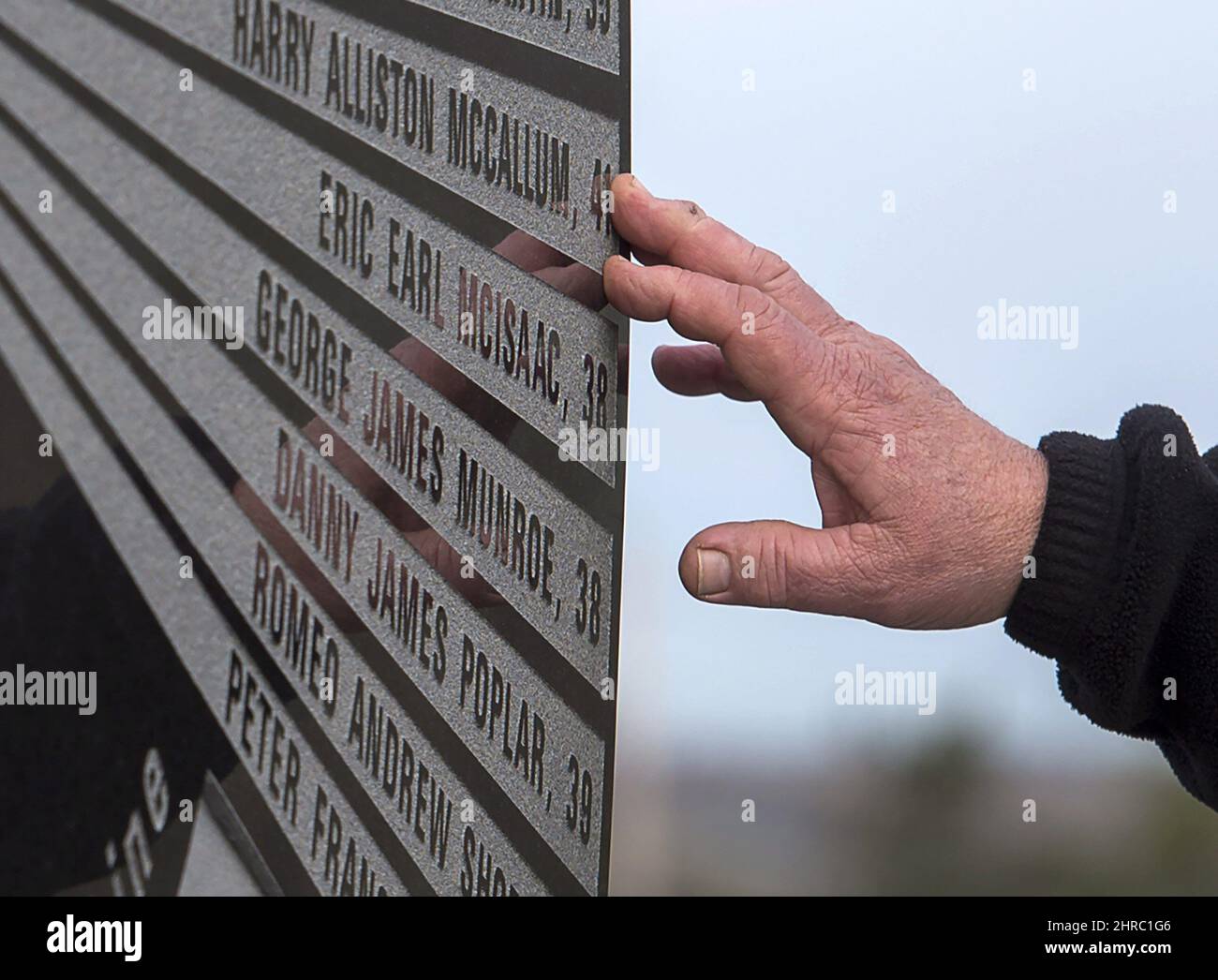 A hand touches the monument that honours the 26 coal miners who ...