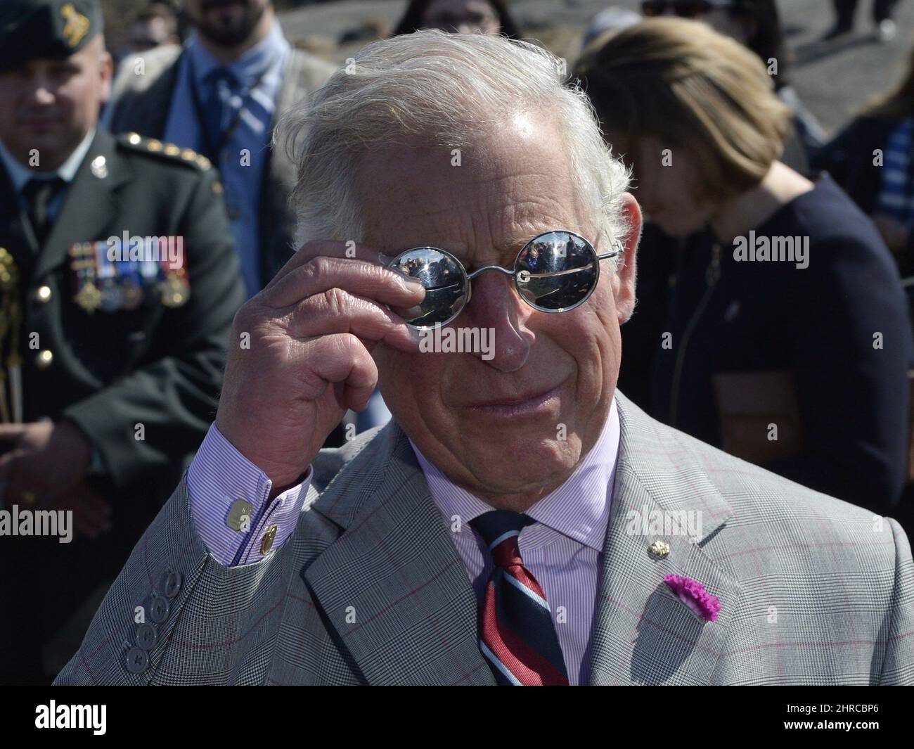 Prince Charles adjusts his sunglasses as he walks around Iqaluit ...