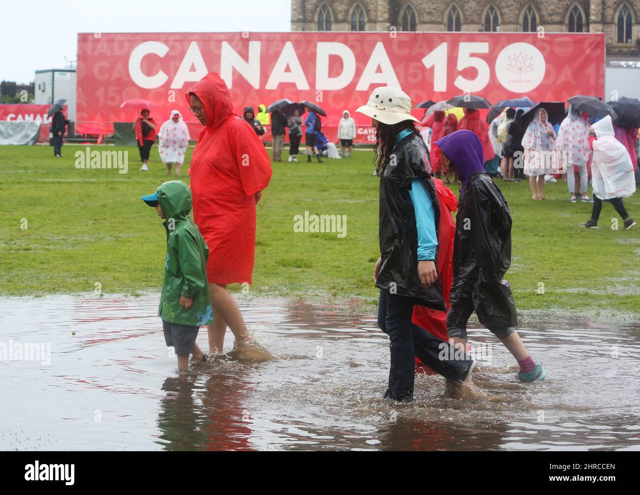 People walk through puddles as they take in the Canada 150 celebrations ...