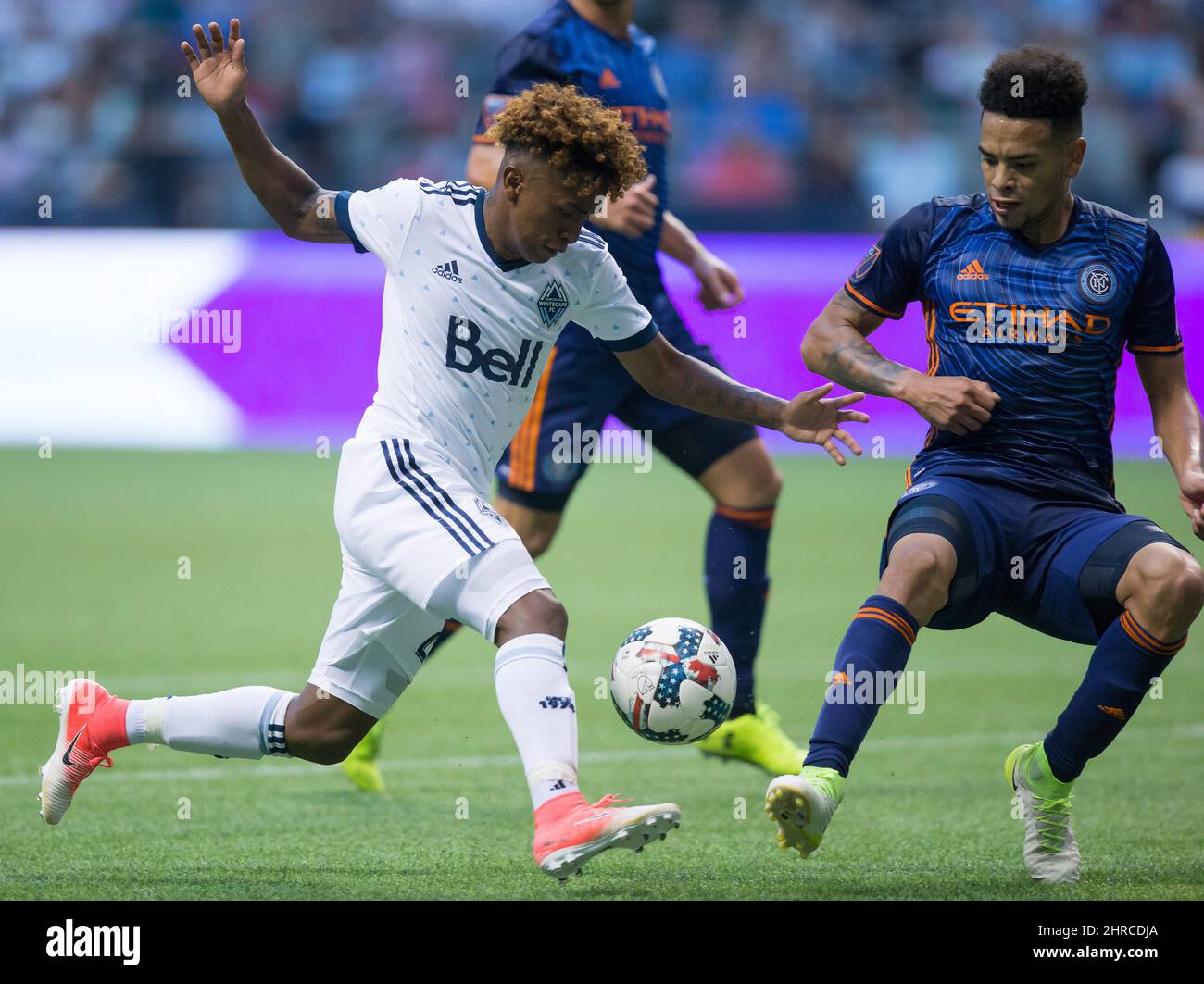 Vancouver Whitecaps' Yordy Reyna, left, tries to move the ball past New ...