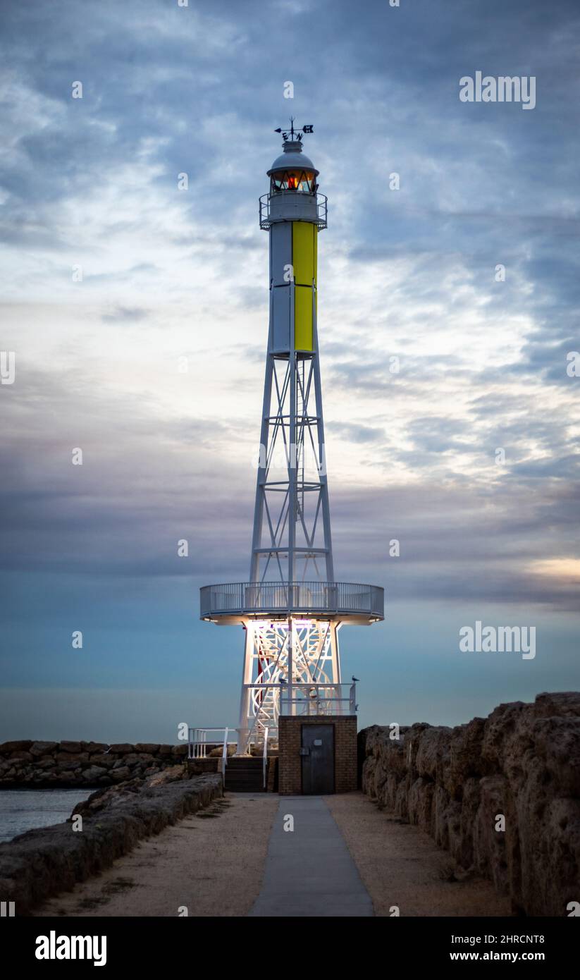 Modern metallic lighthouse at dusk against a cloudy sky Stock Photo - Alamy