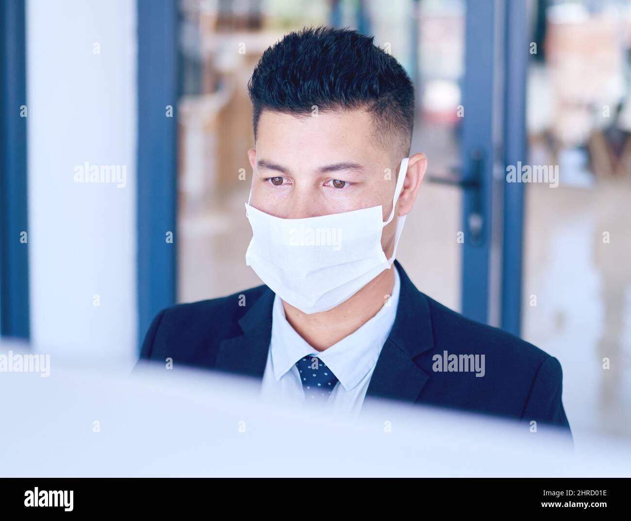 First rule of office work Wear a face mask. Shot of a young businessman ...