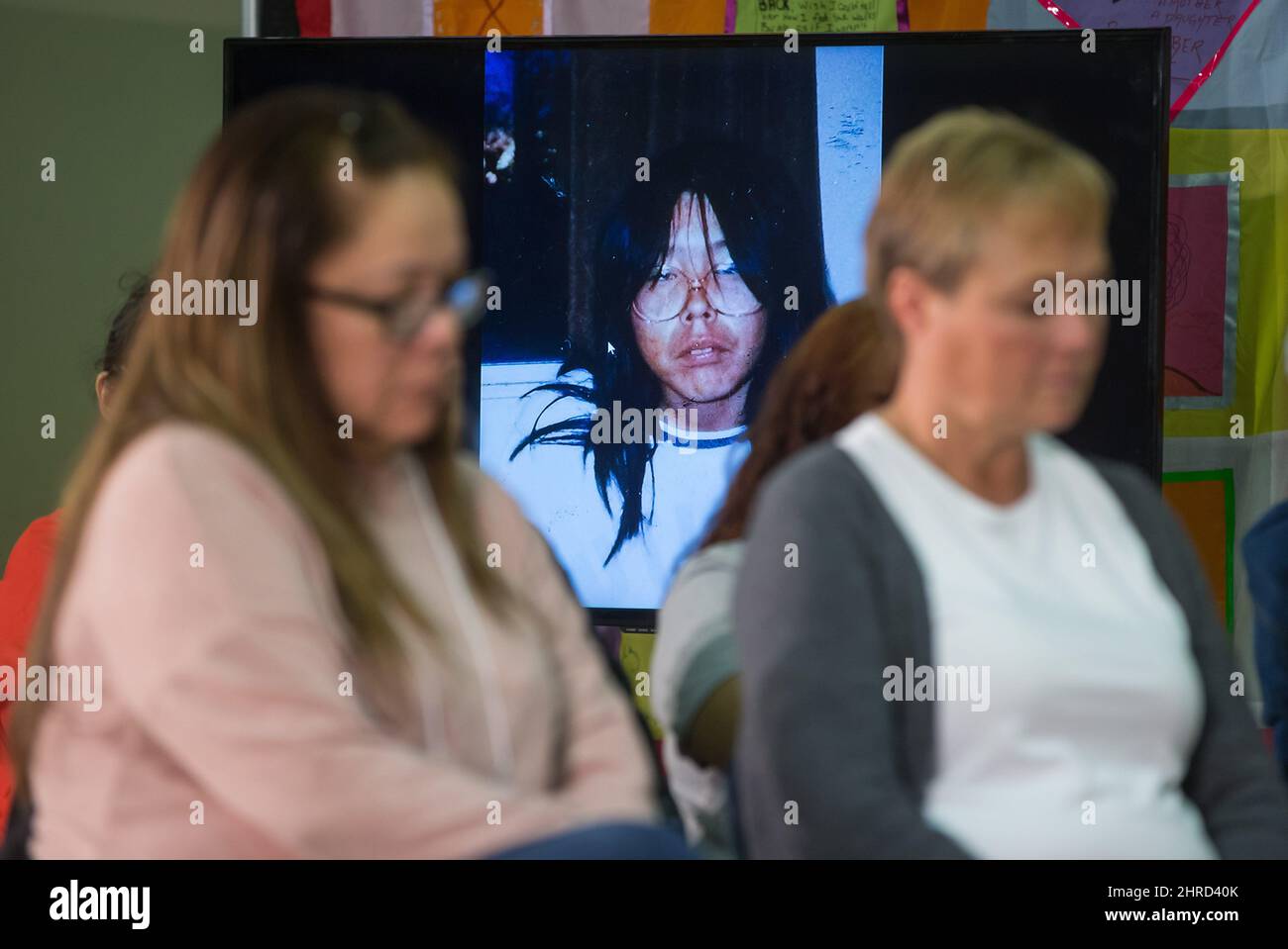 A photo of Doreen Jack is displayed on a screen as people listen to ...