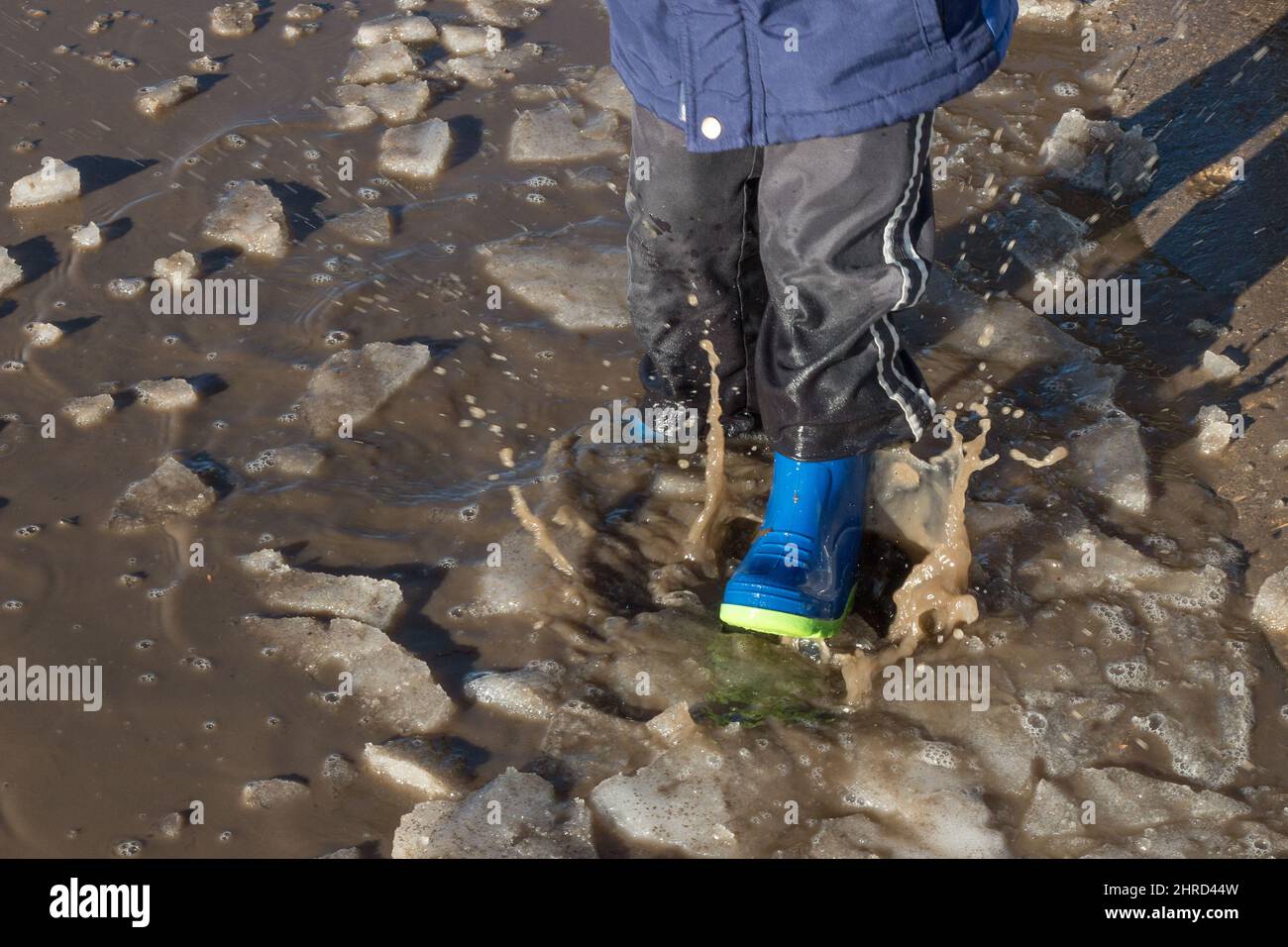 Boy splashing in icy puddles Stock Photo - Alamy