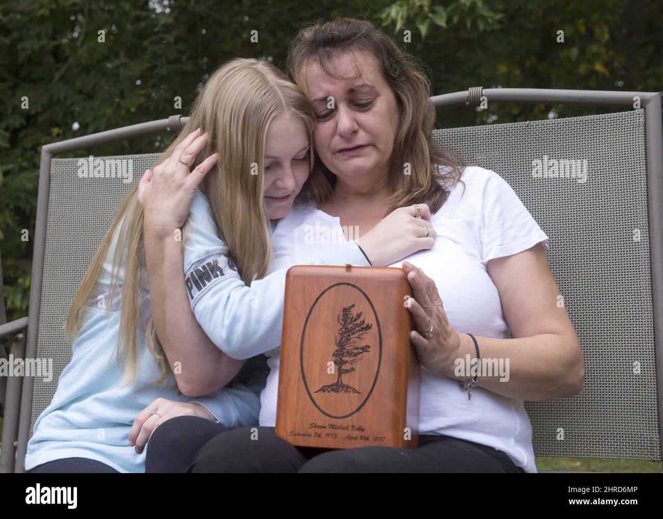 Denise Lane and her daughter Megan sit with the urn containing the ...