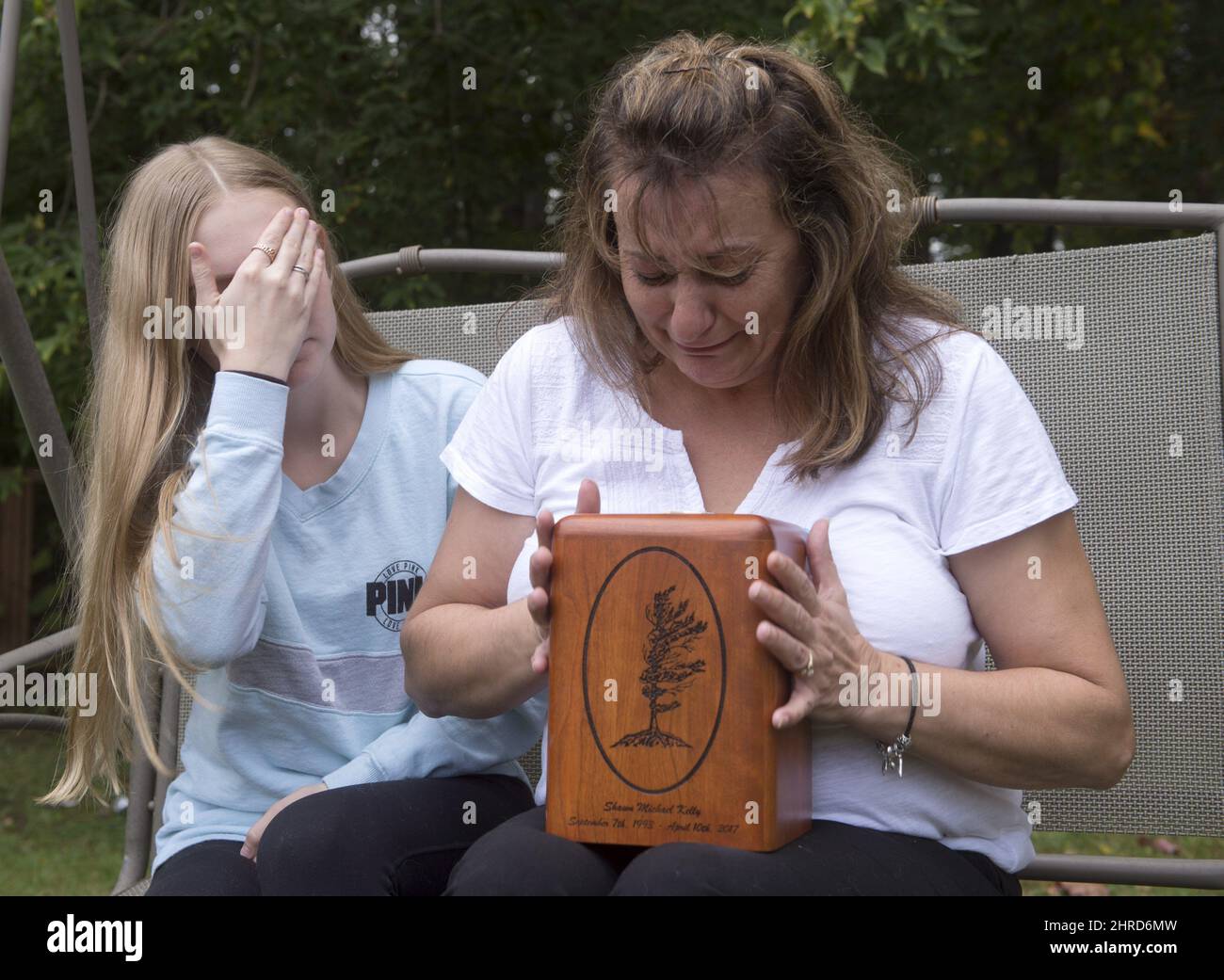 Denise Lane and her daughter Megan sit with the urn containing the ...