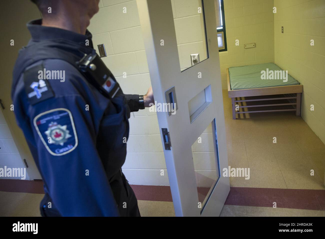A corrections officer opens the door to a cell in the segregation unit ...