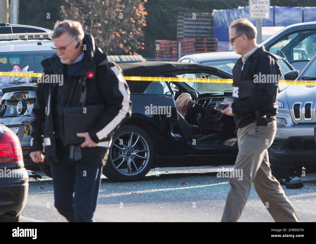 Police officers investigate the scene of a shooting that left one ...