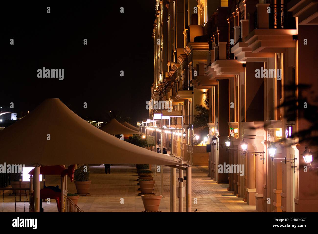 Beautiful street lit up by lights at nighttime with a modern building ...