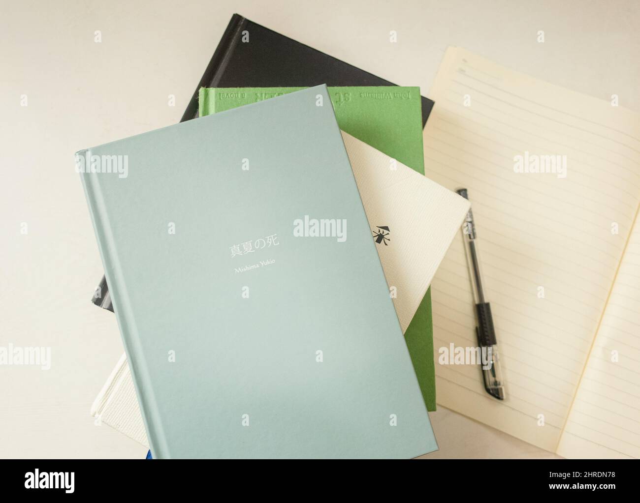 Top view of a stack of notebooks next to a pen and paper Stock Photo ...