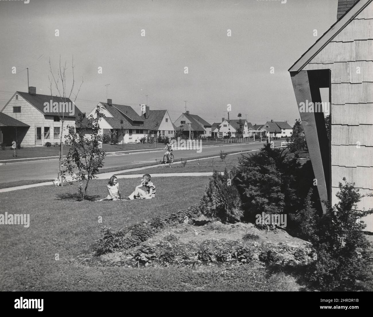 1950s SUBURBAN NEIGHBORHOOD HOUSING DEVELOPMENT TWO KIDS PLAYING ON ...