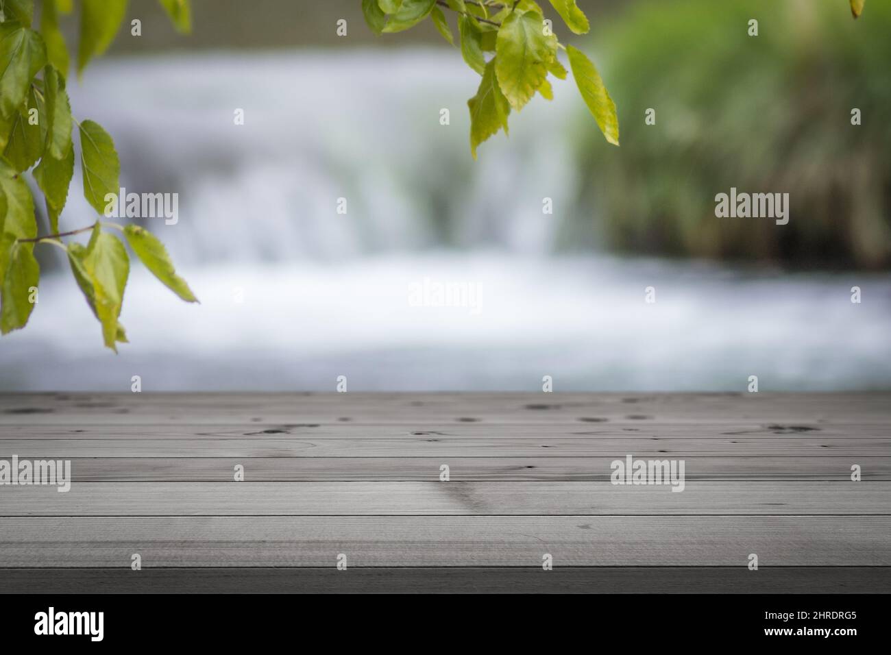 Wooden table against the blurry background with a flowing river with ...