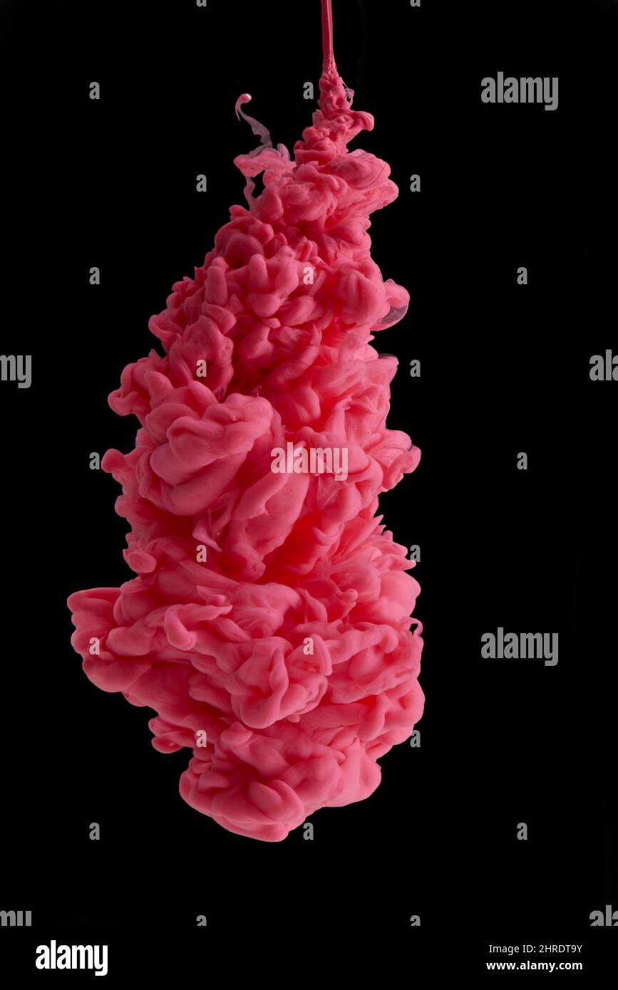Color chemistry. Studio shot of pink ink in water against a black ...