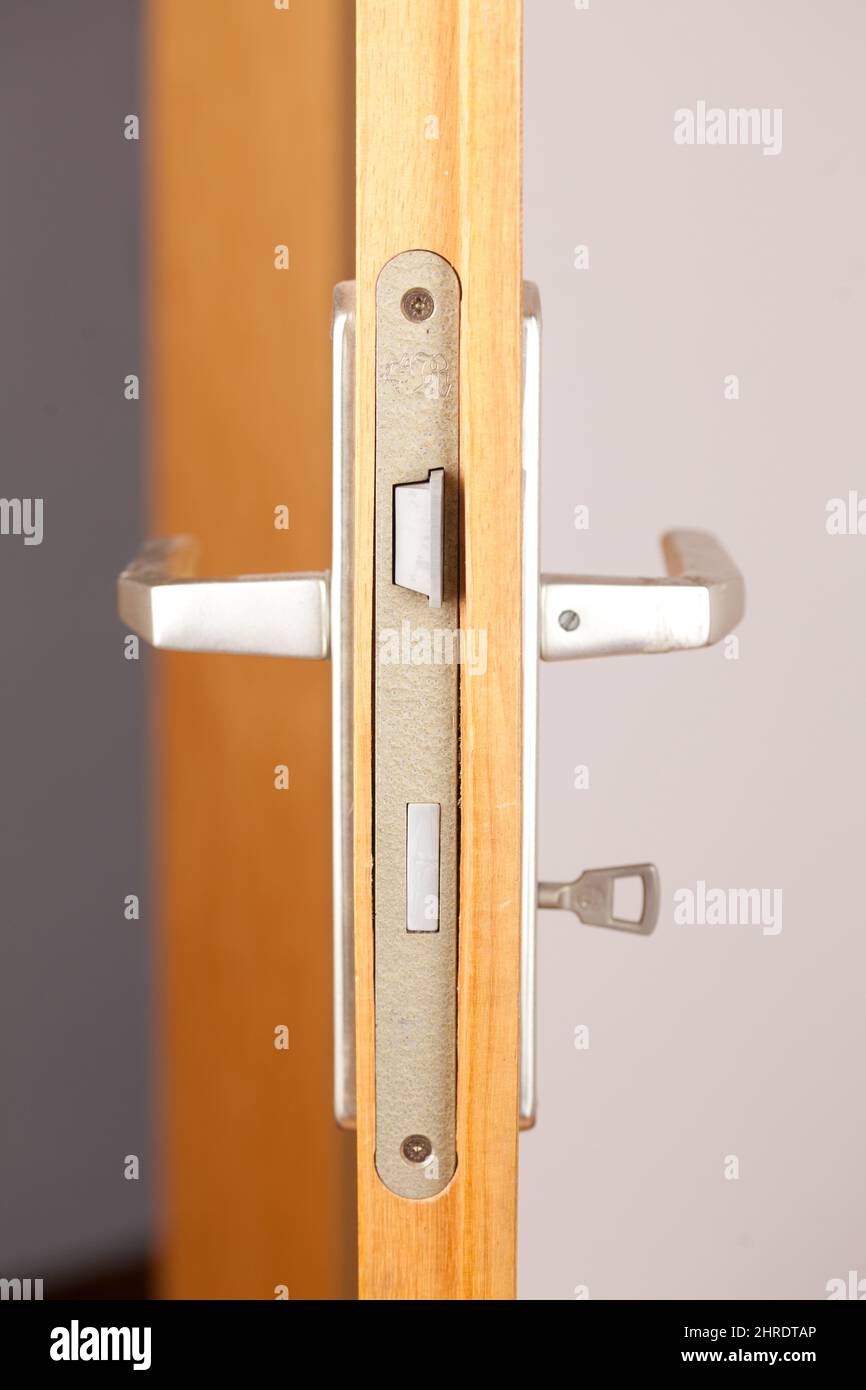 Vertical of a silver mortise lock on a light brown wooden door Stock ...