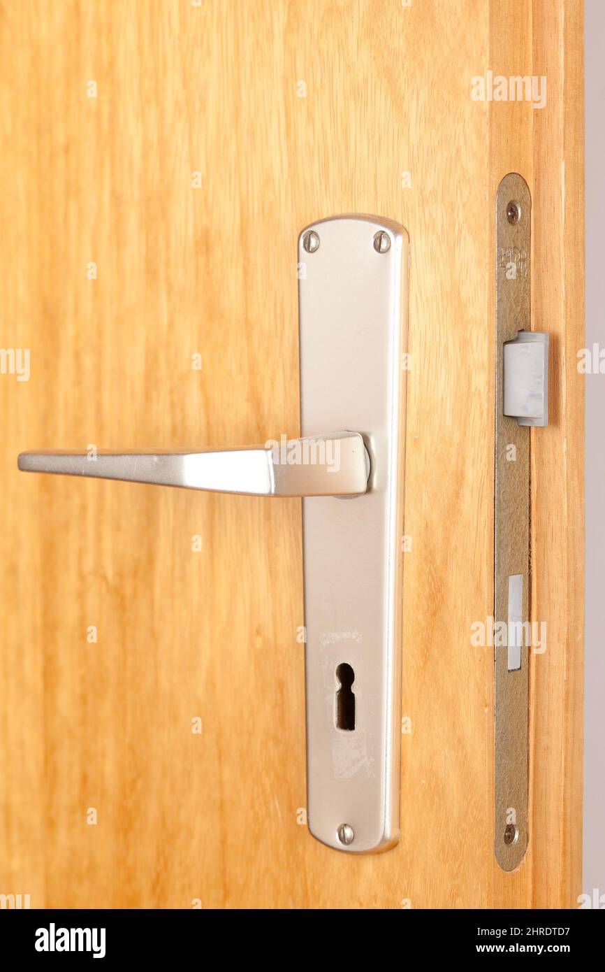 Vertical of a silver mortise lock on a light brown wooden door Stock ...