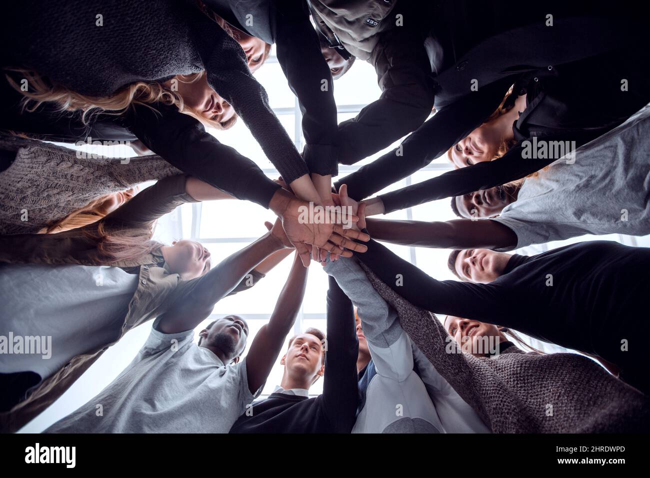 bottom view. group of happy young people making a tower out of their ...