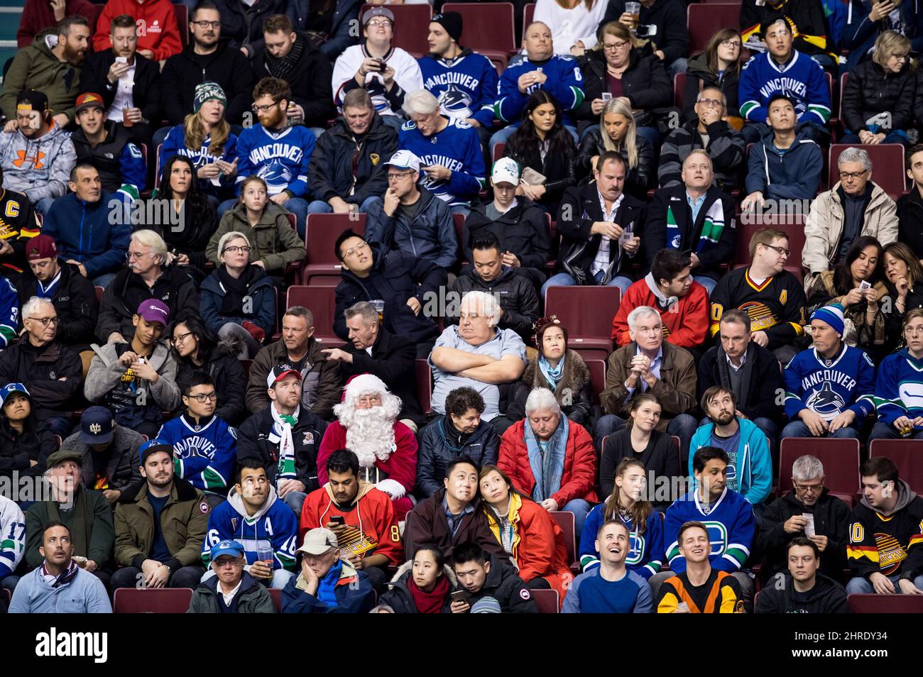 A spectator dressed as Santa Claus sits among the crowd as the ...