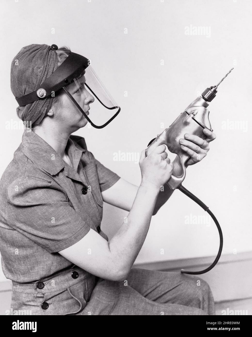 1940s FEMALE DEFENSE WORKER HOLDING A DRILL WEARING PROTECTIVE FACE ...