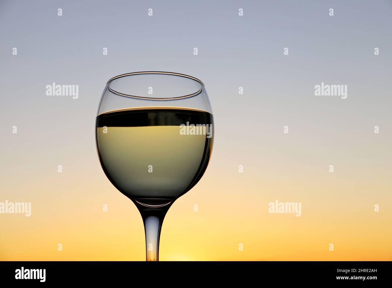 Glass with white wine on sunset sky background. Concept of celebration ...