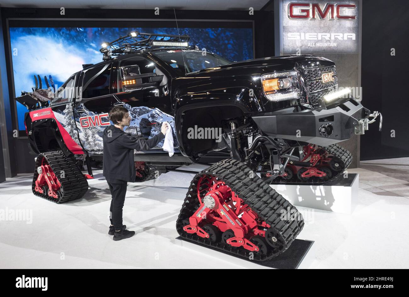 A worker cleans a GMC Sierra All Mountain truck in preparation for the ...