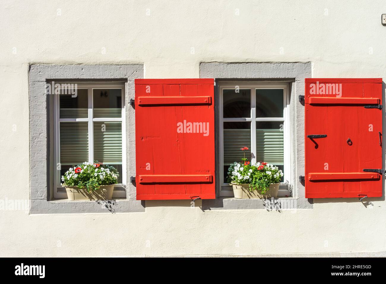 White wall with windows and red wooden cover Stock Photo - Alamy
