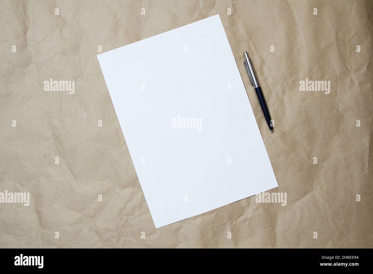 White empty sheet of A4 format with pen on a beige craft paper. Concept ...
