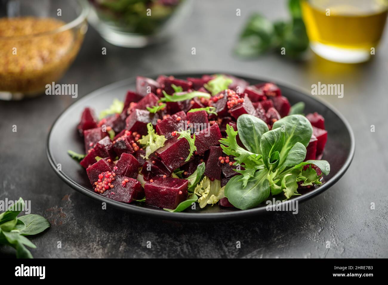 Beet salad with mustard and greens. Dark background Stock Photo - Alamy