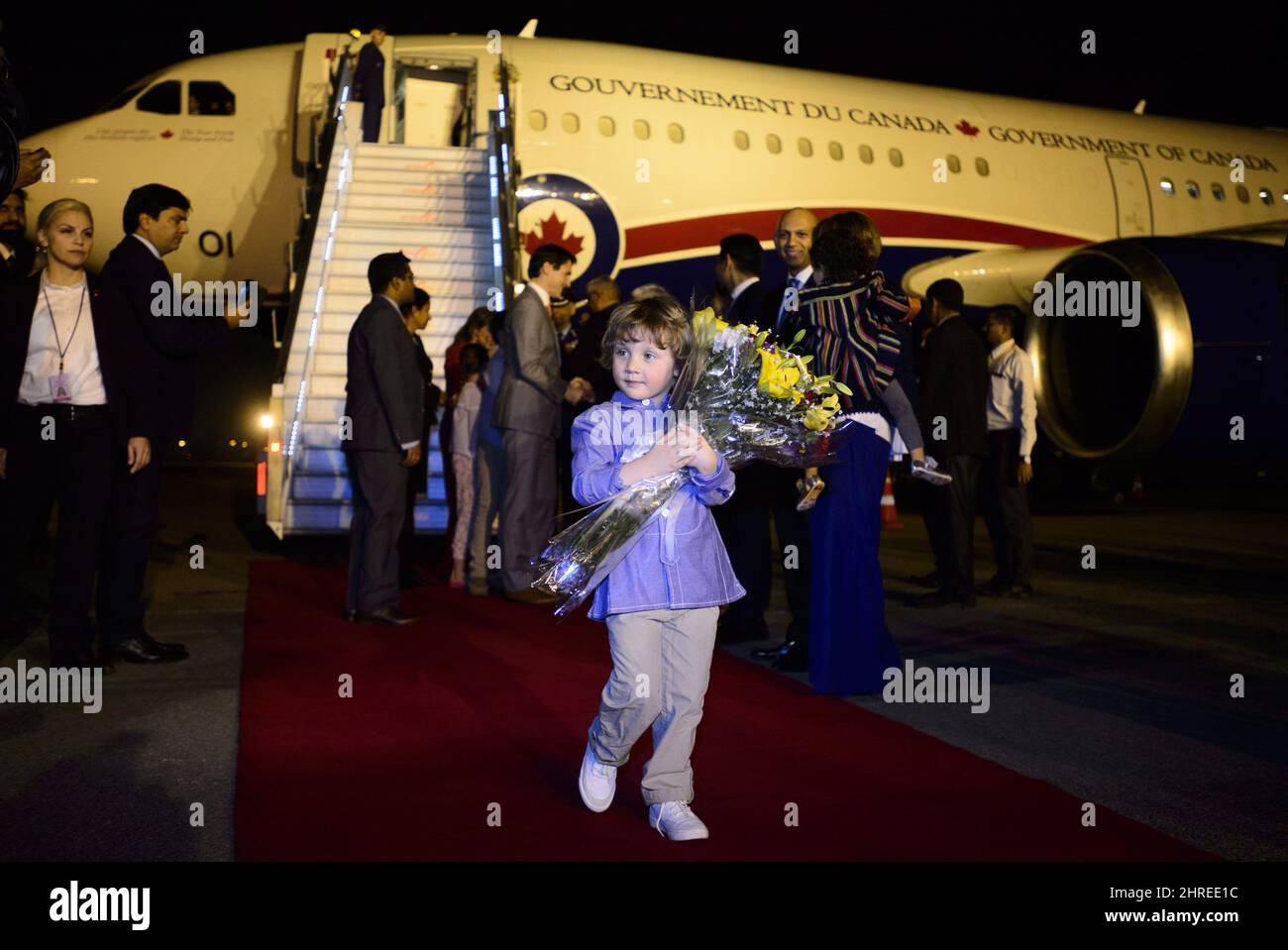 Hadrien Trudeau, 3, carries a bouquet of flowers received as he arrives ...