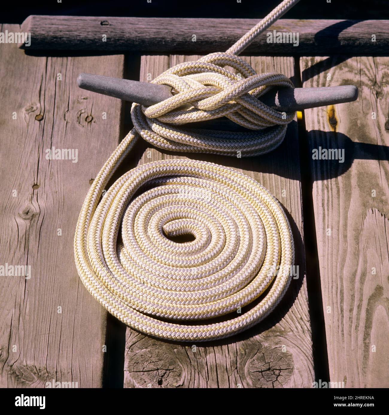 1970s CLOSE-UP COILED ROPE ON BOAT DOCK NEXT TO SECURING HORN CLEAT ...