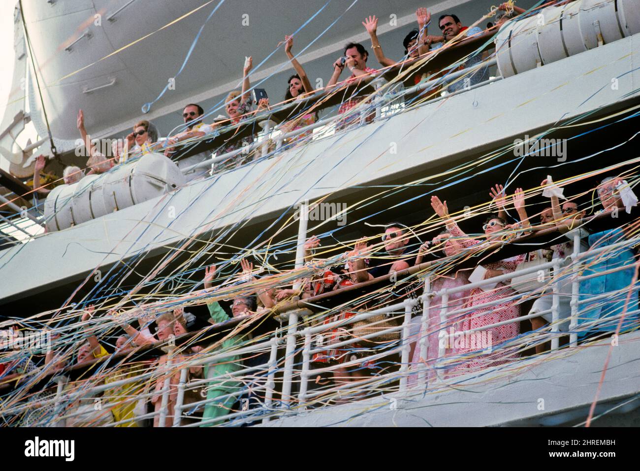 1980s DEPARTING CRUISE SHIP PASSENGERS WAVING GOODBYE AMID SHOWER OF ...
