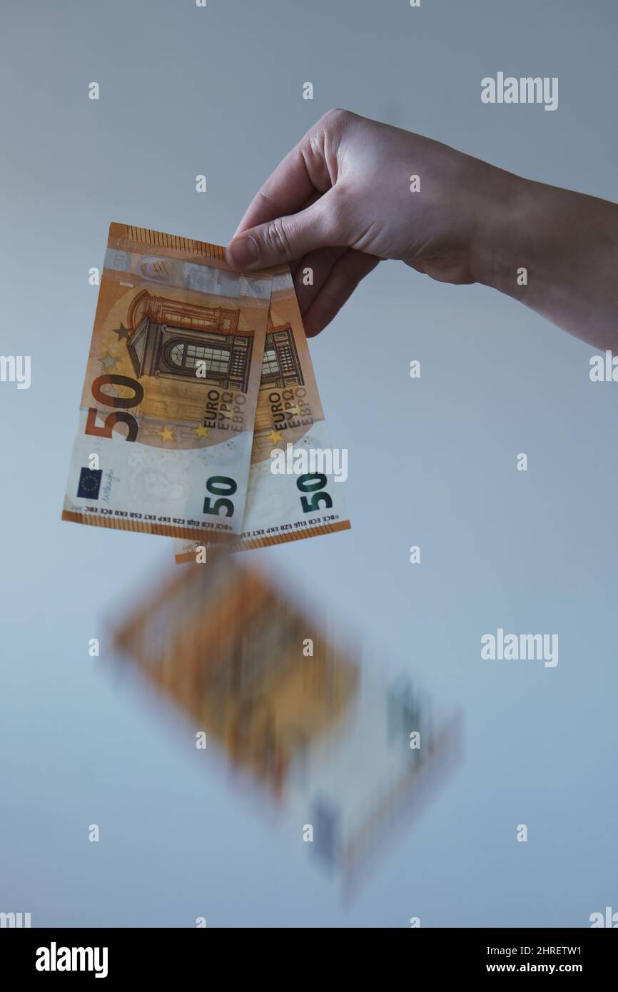 Hand holding 50 euro banknotes against a white wall Stock Photo - Alamy