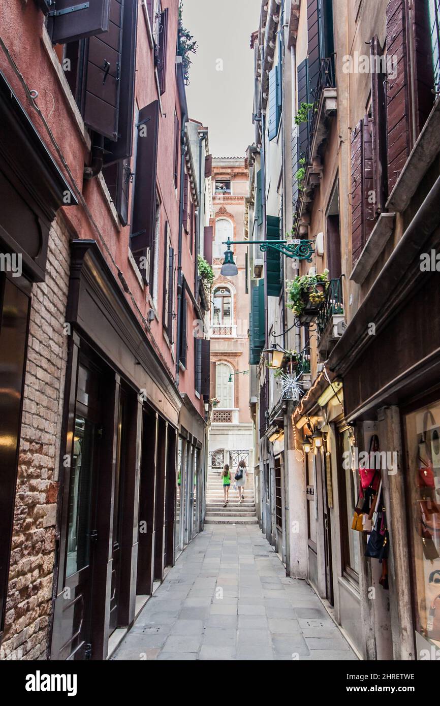 View of the narrow long street surrounded by buildings Stock Photo - Alamy